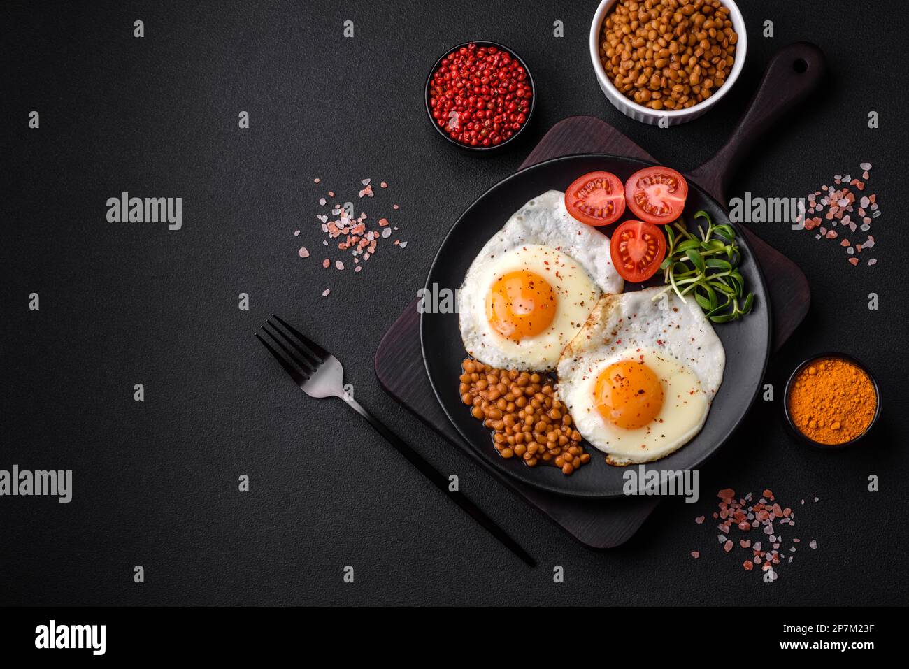 Delicious hearty breakfast consisting of two fried eggs, canned lentils ...