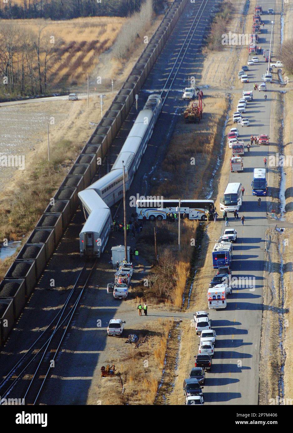 Workers remove passengers’ luggage from the scene of an Amtrak ...