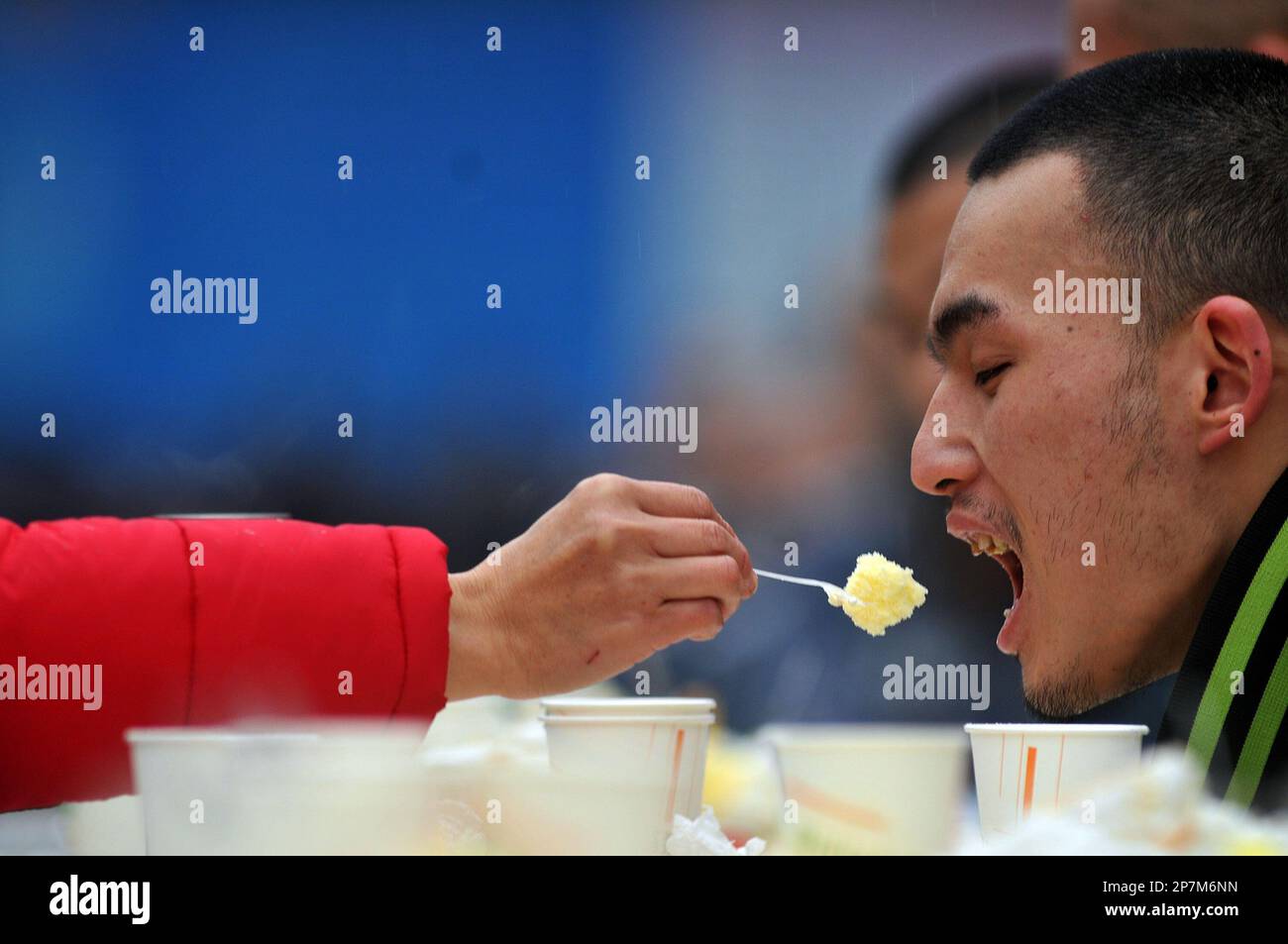 An inmate and his mother share a cake during a mass birthday party for ...