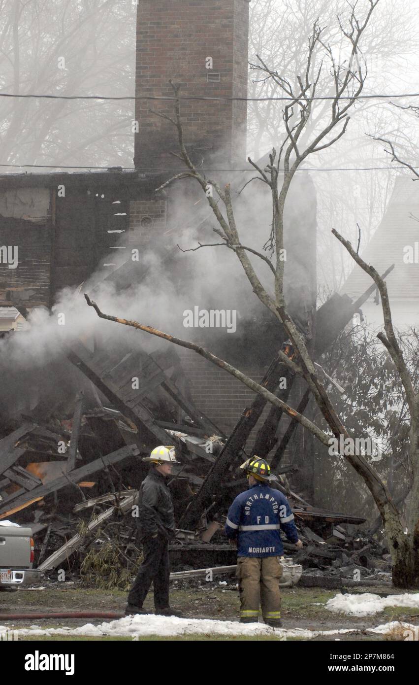 Firefighters attend to the scene of a fire Sunday Dec. 27, 2009, as a ...