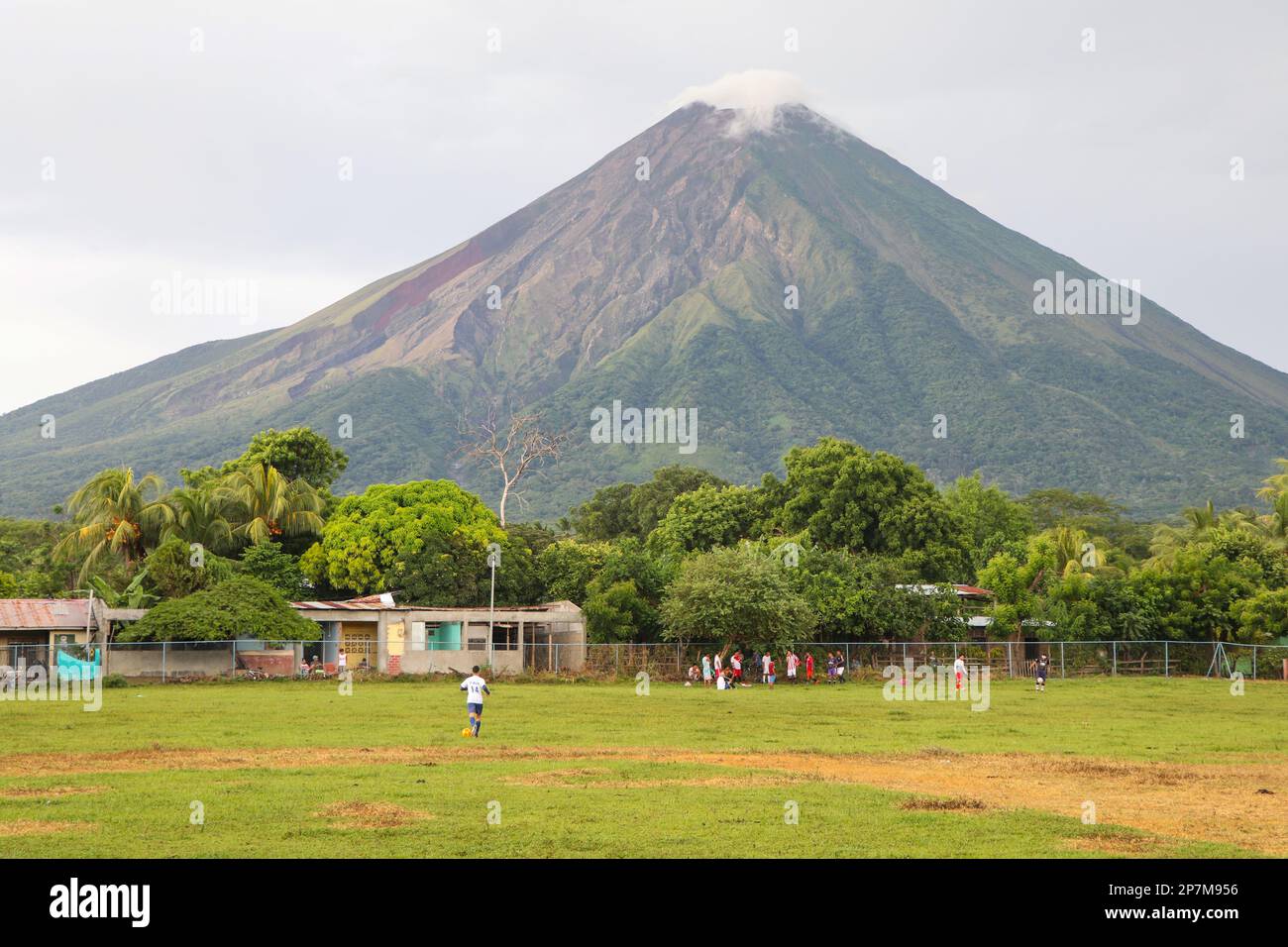 People playing soccer game at the foot of the volcano, Ometepe island ...