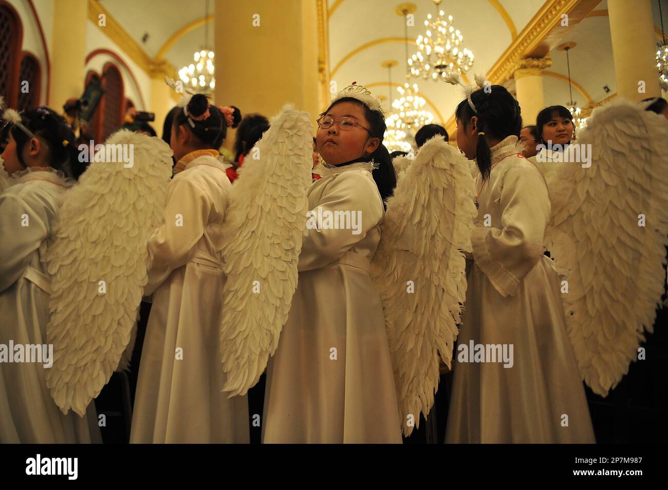 Children dressed as angels pray during a Christmas mass in the ...