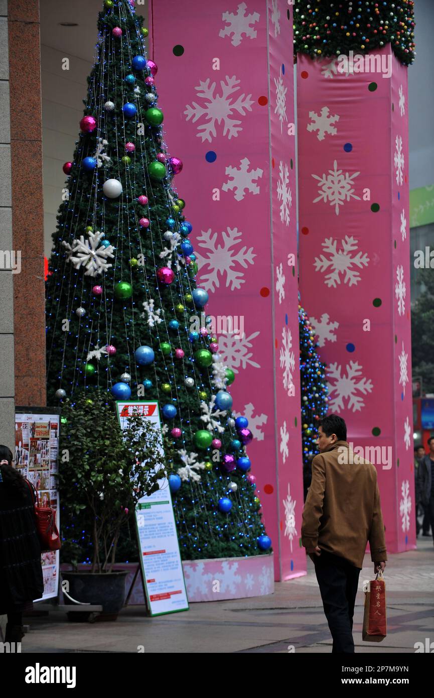 A customer walks past a Christmas tree outside a shopping mall in ...
