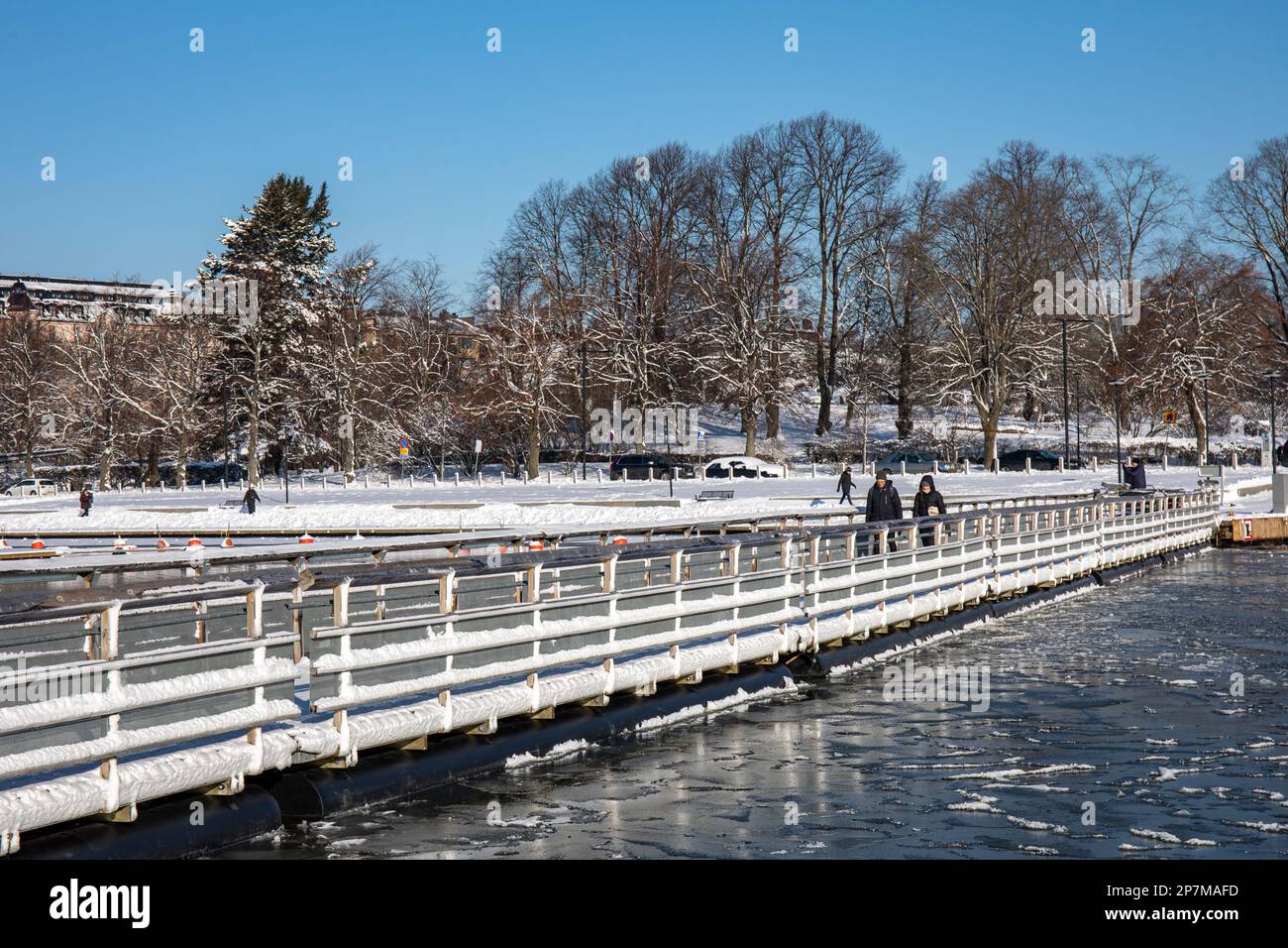 People on a pontoon bridge from Kaivopuisto to Uunisaari on a sunny ...