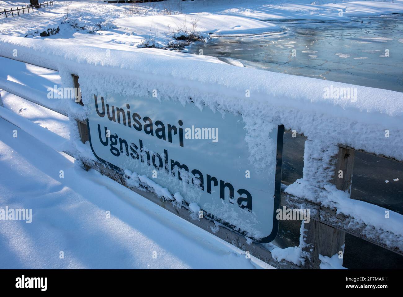 Snow-covered Uunisaari sign on pier railing in Helsinki, Finland Stock ...