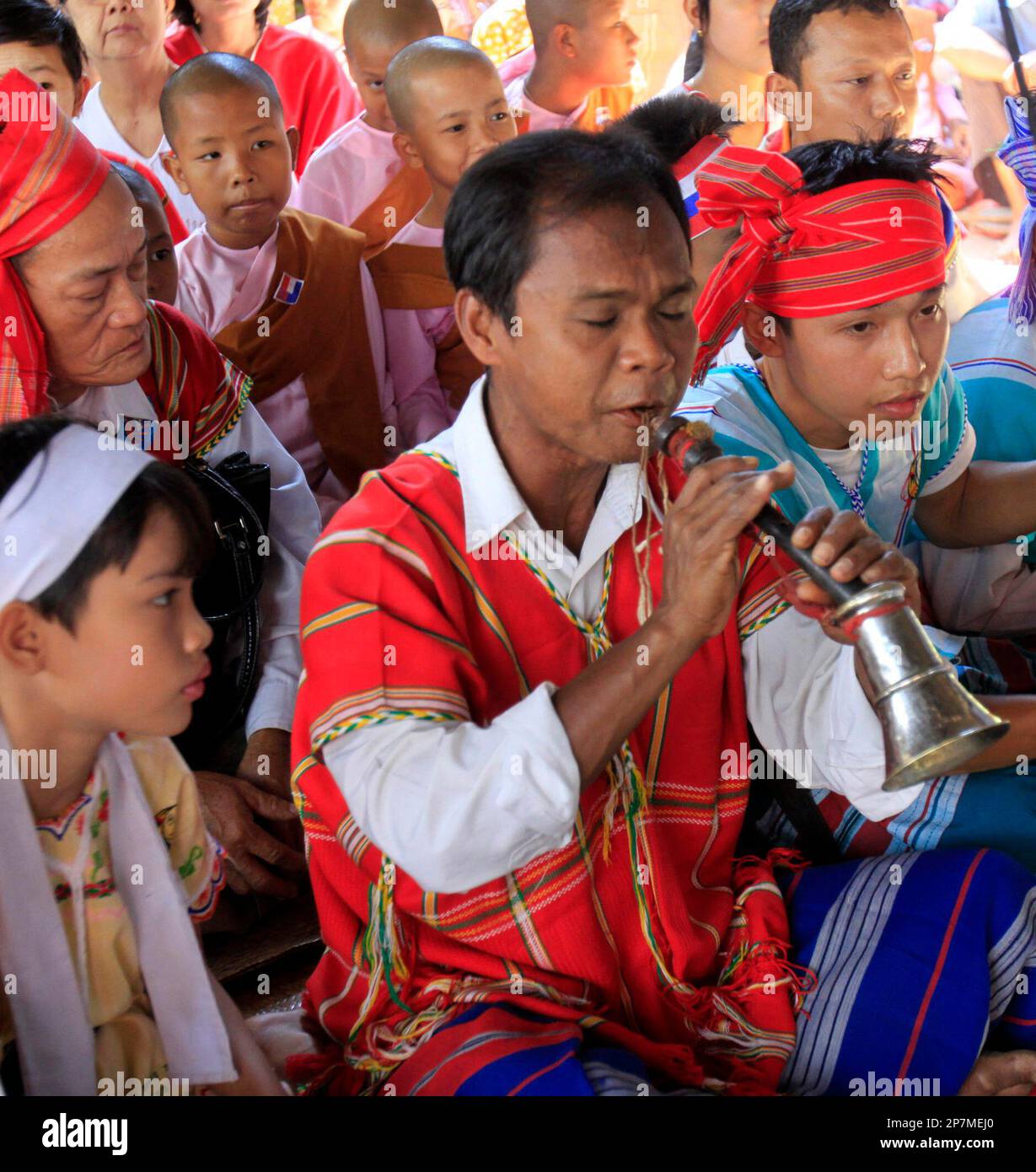 A Kayin ethnic tribesman plays oboe to entertain the audience during ...