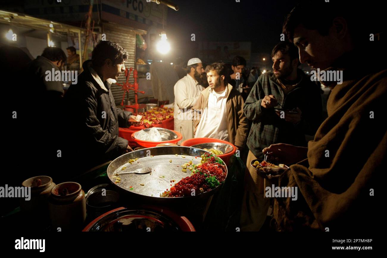 Pakistani have snacks at a market in the old city of Rawalpindi ...