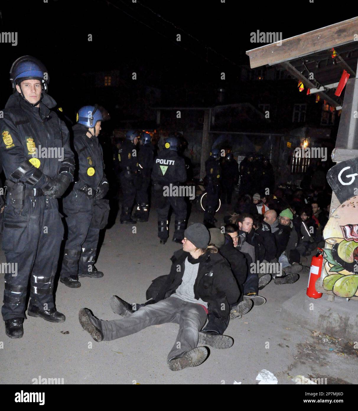 Police officers stand by detained protesters after riots broke out in ...
