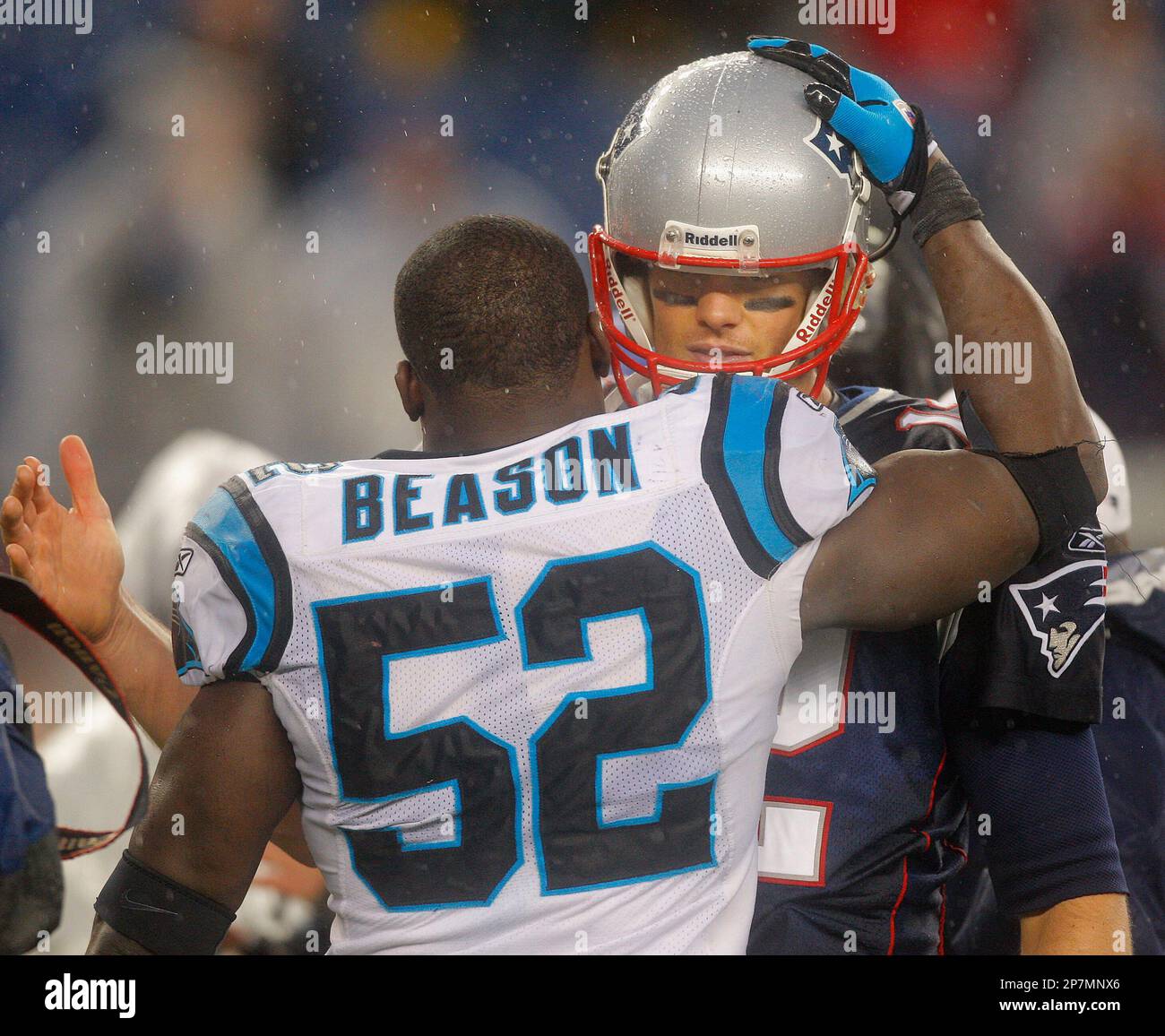 New England Patriots quarterback Tom Brady (12) is patted on the head by Carolina Panthers ...