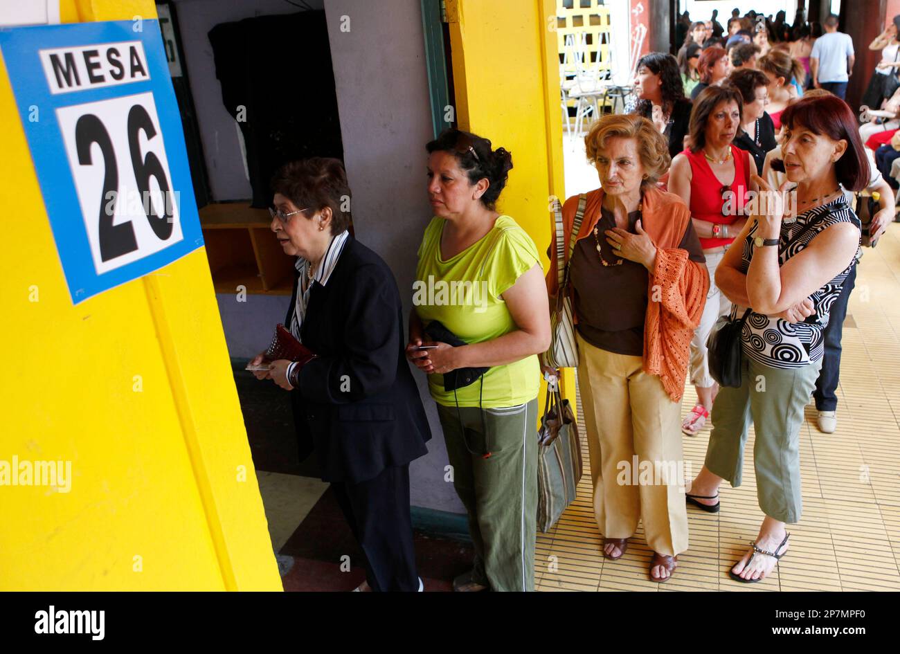 Voters stand in line at a polling station during general elections in ...