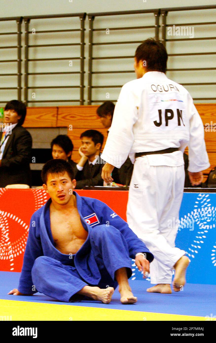 Musashi Ogura of Japan, in white uniform, leaves the competition venue ...