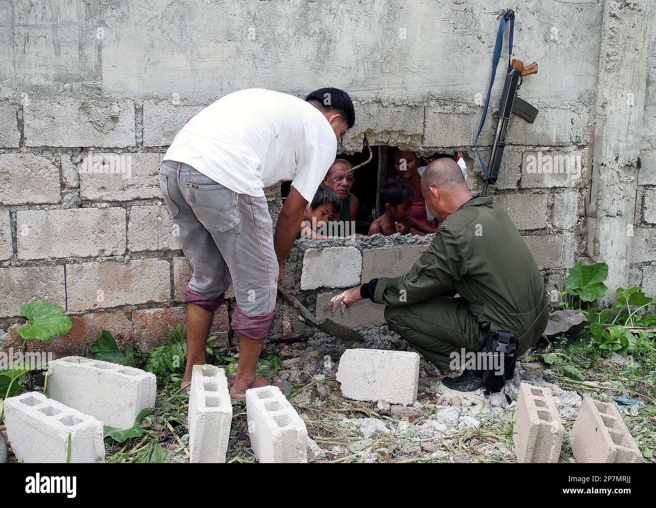 Prison guards cover a hole that was destroyed during an attack of about ...
