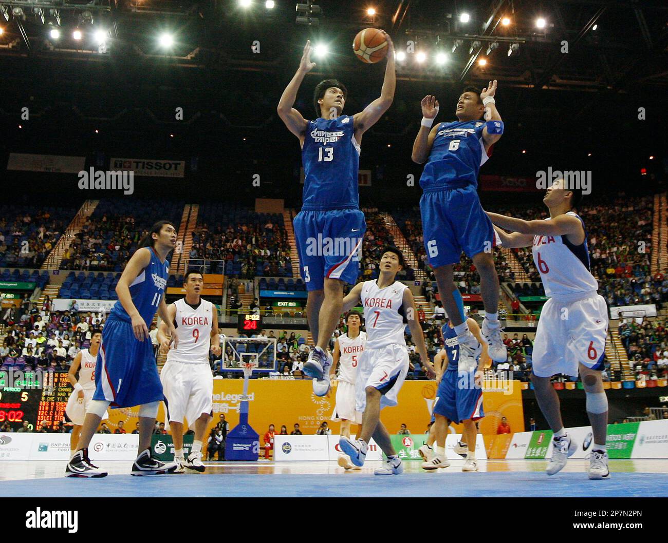 Taiwanese players, in blue jersey, jump to haul a rebound against South ...