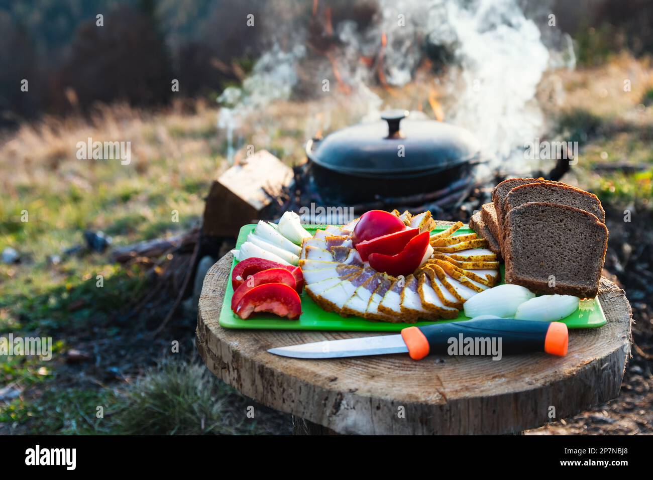 Food is prepared in a cauldron at the campsite. Fat and black bread ...