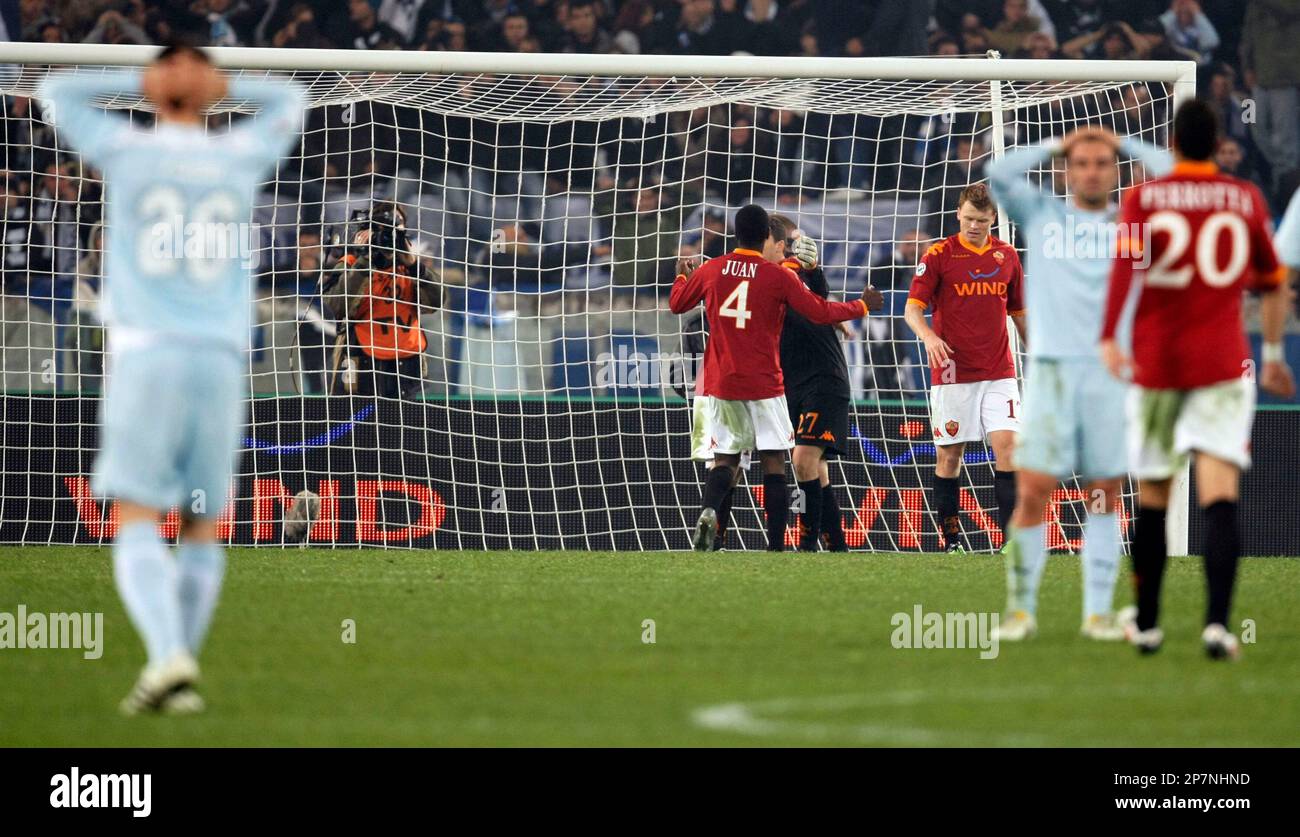 As Roma players, in red jersey, react with their goalkeeper Julio ...