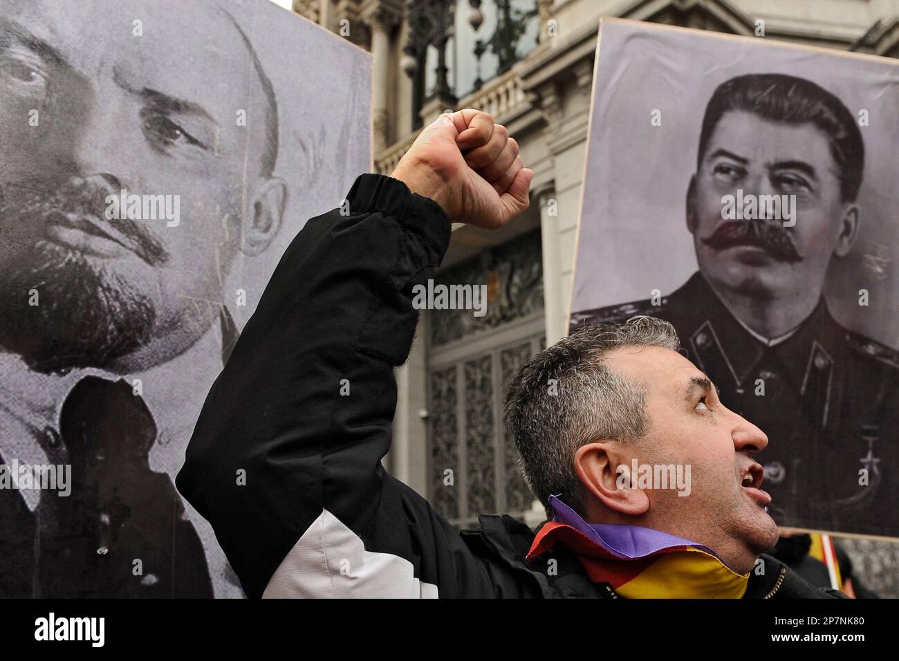 A man reacts in front the portraits of Russian leaders Stalin and Lenin ...