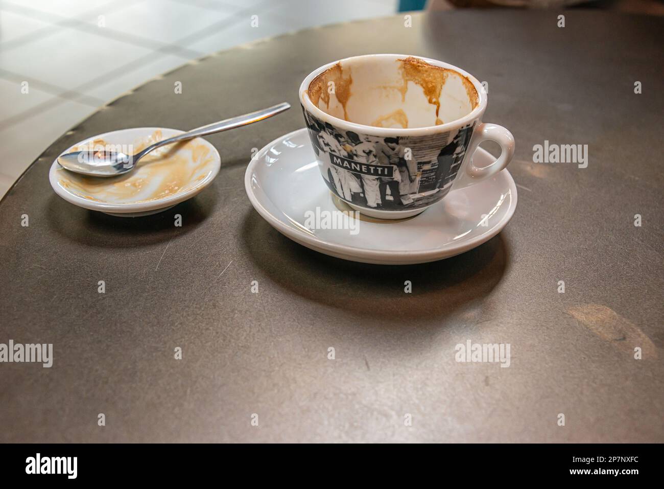 cup and saucer used by customer with small white dish placed on a table ...