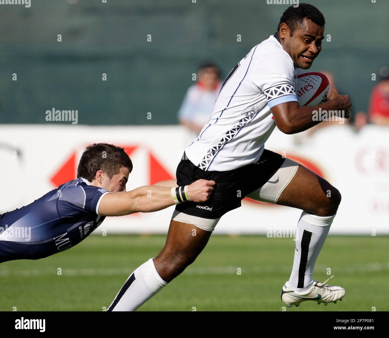 Fiji's Niumaia Rokobuli, right, runs as Scotland's Peter Jericevich ...