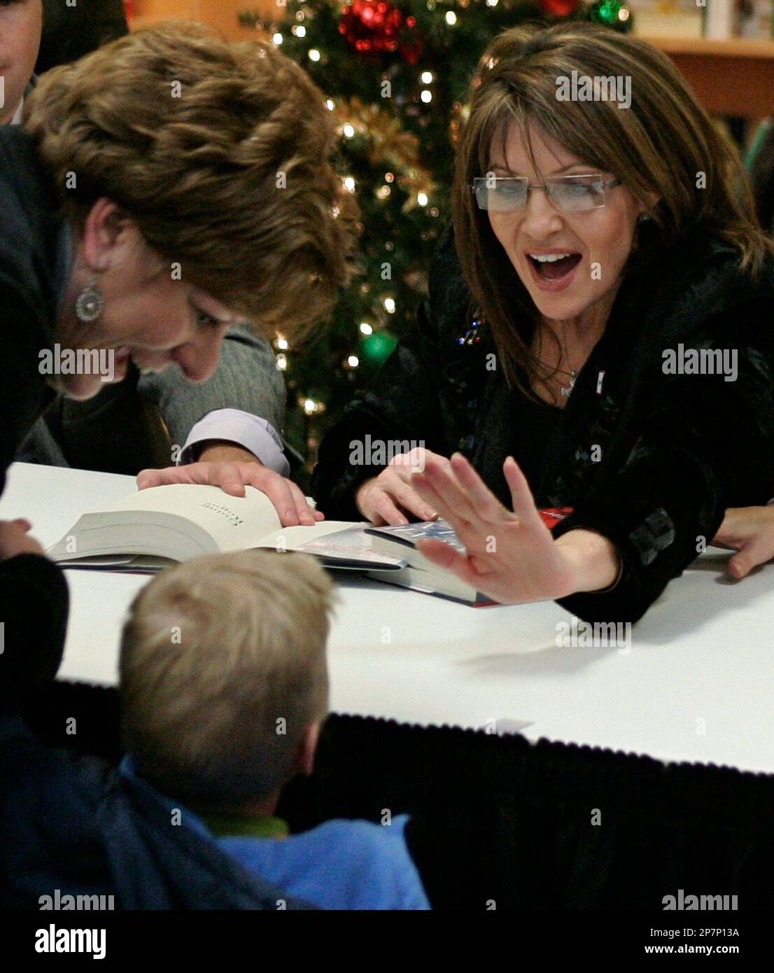 Former Alaska Gov. Sarah Palin waves at a young boy during a book ...