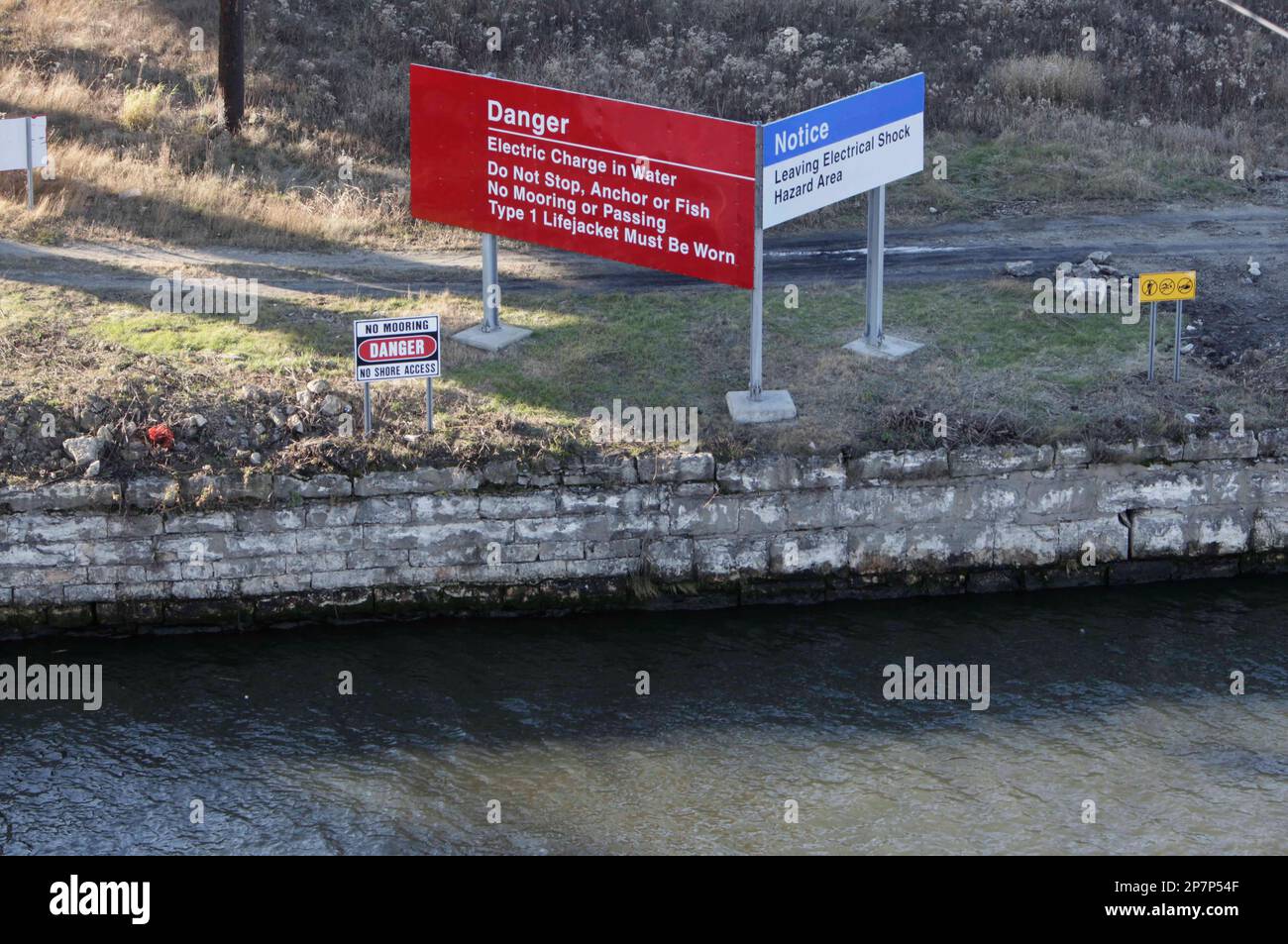 Signs warn river traffic about a section of water containing an ...