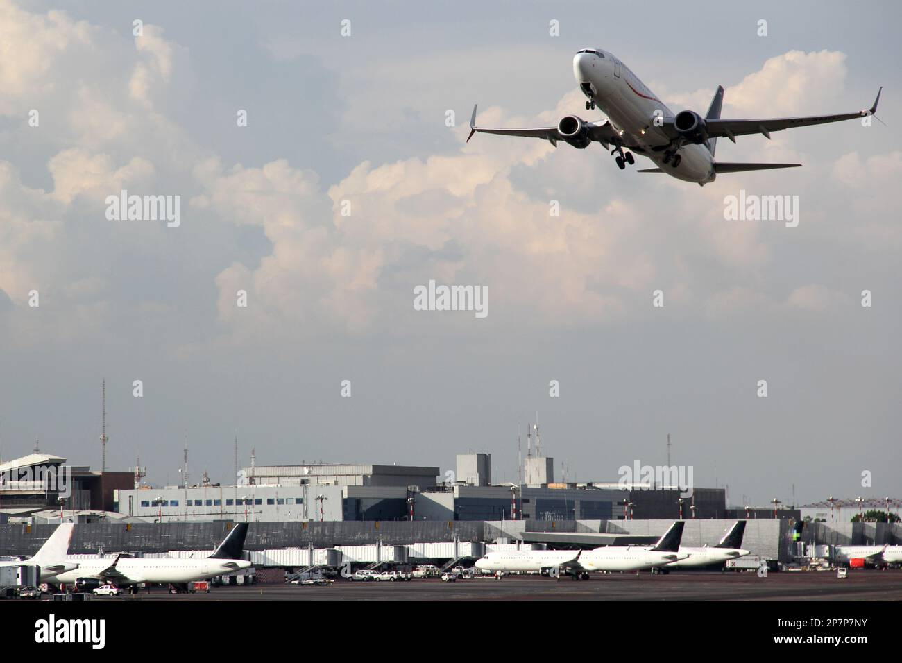 Airplane taking off or landing on runway with blue sky between clouds ...