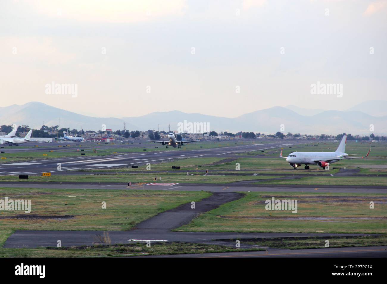 Commercial airplane parked, taking off or landing on runway under blue ...