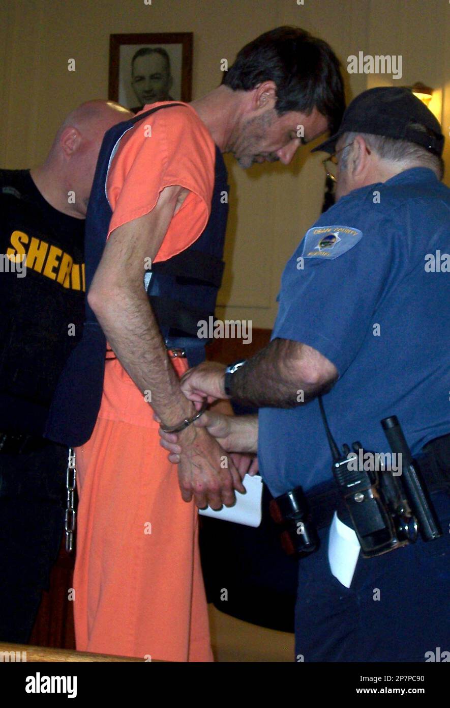 James Kraig Kahler, center, is handcuffed after his first court ...