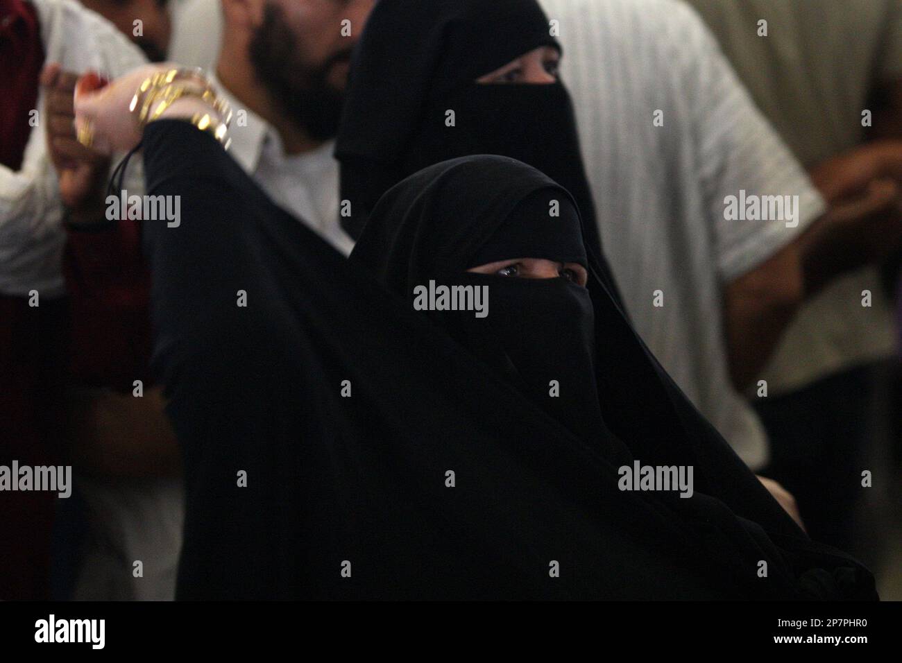 A Muslim pilgrim casts stones at a pillar, symbolizing the stoning of ...