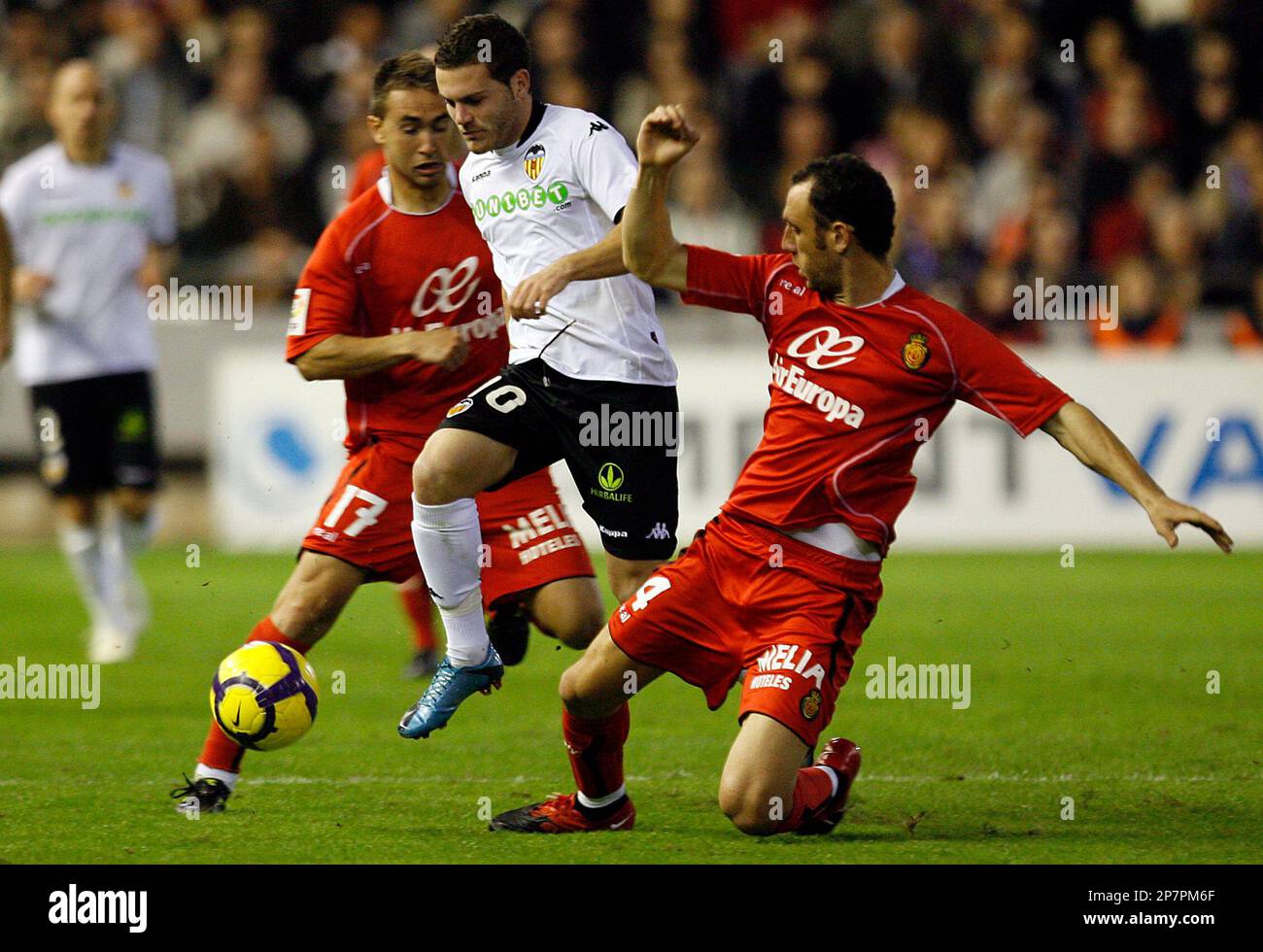 Valencia's Juan Manuel Mata, center, drives the ball followed by ...