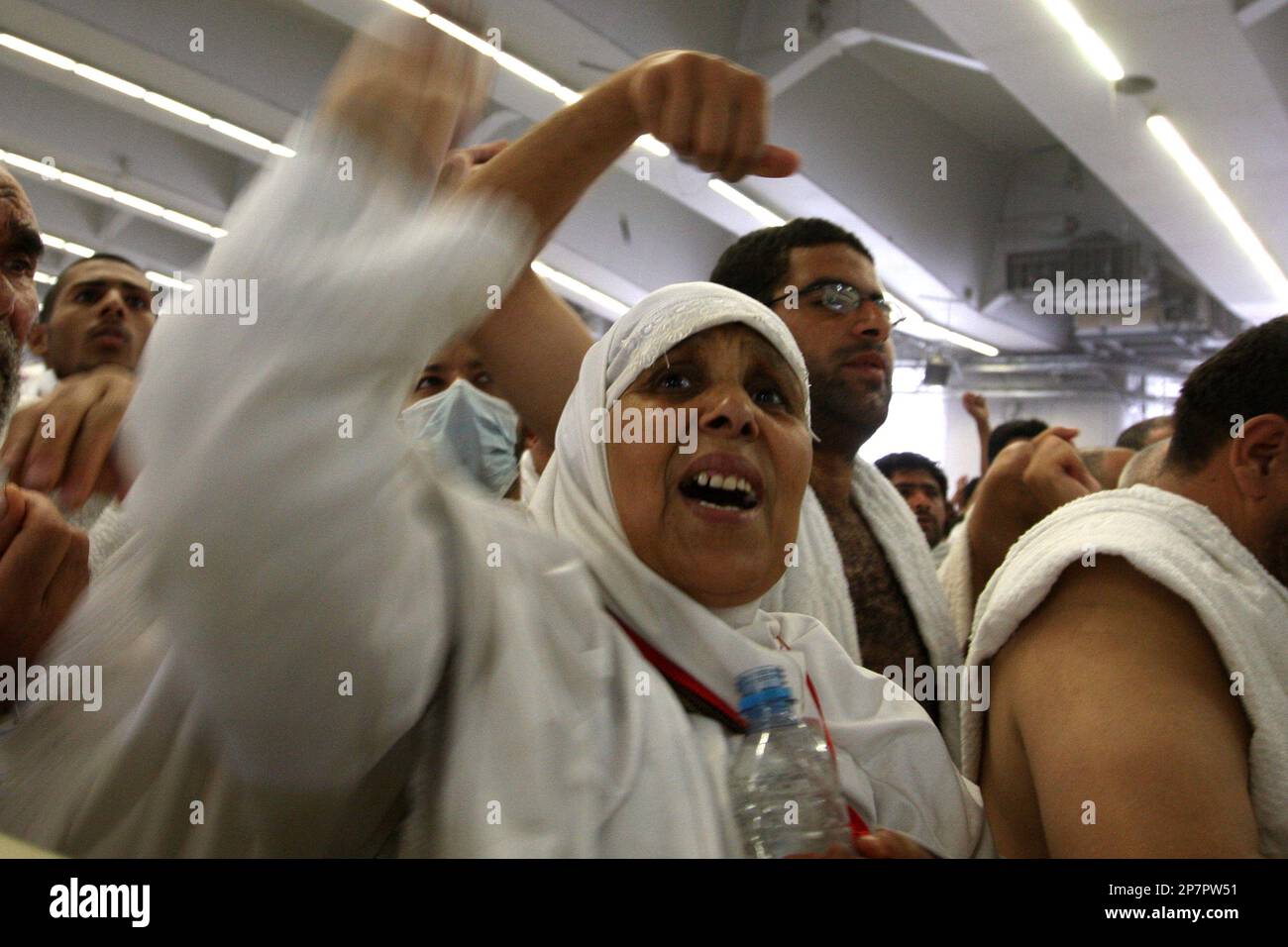 A Muslim pilgrim throws pebbles at a stone pillar representing the ...
