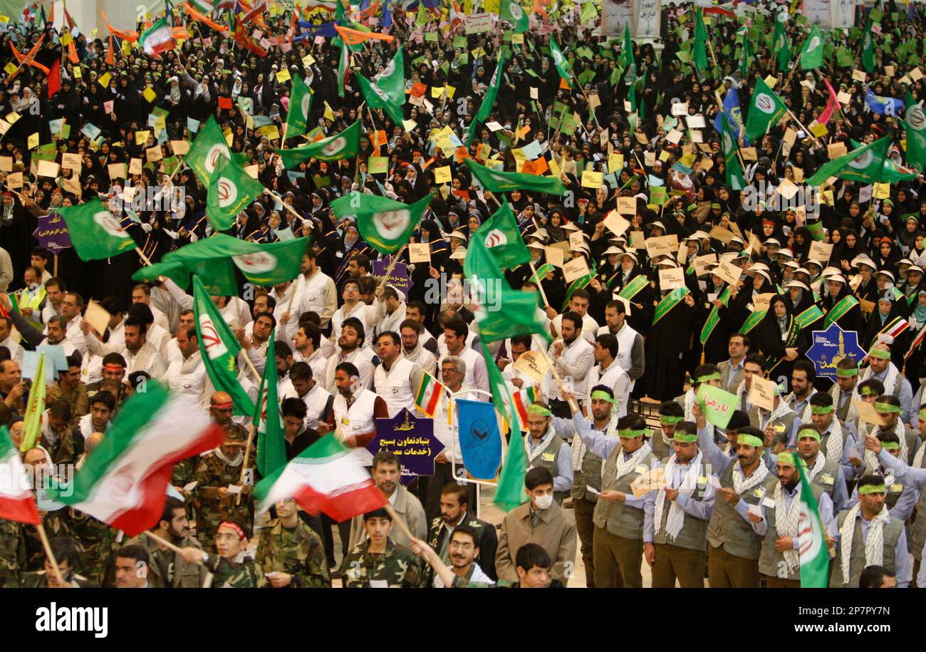 Waving their flags, members of the Iranian Basij militia affiliated to ...