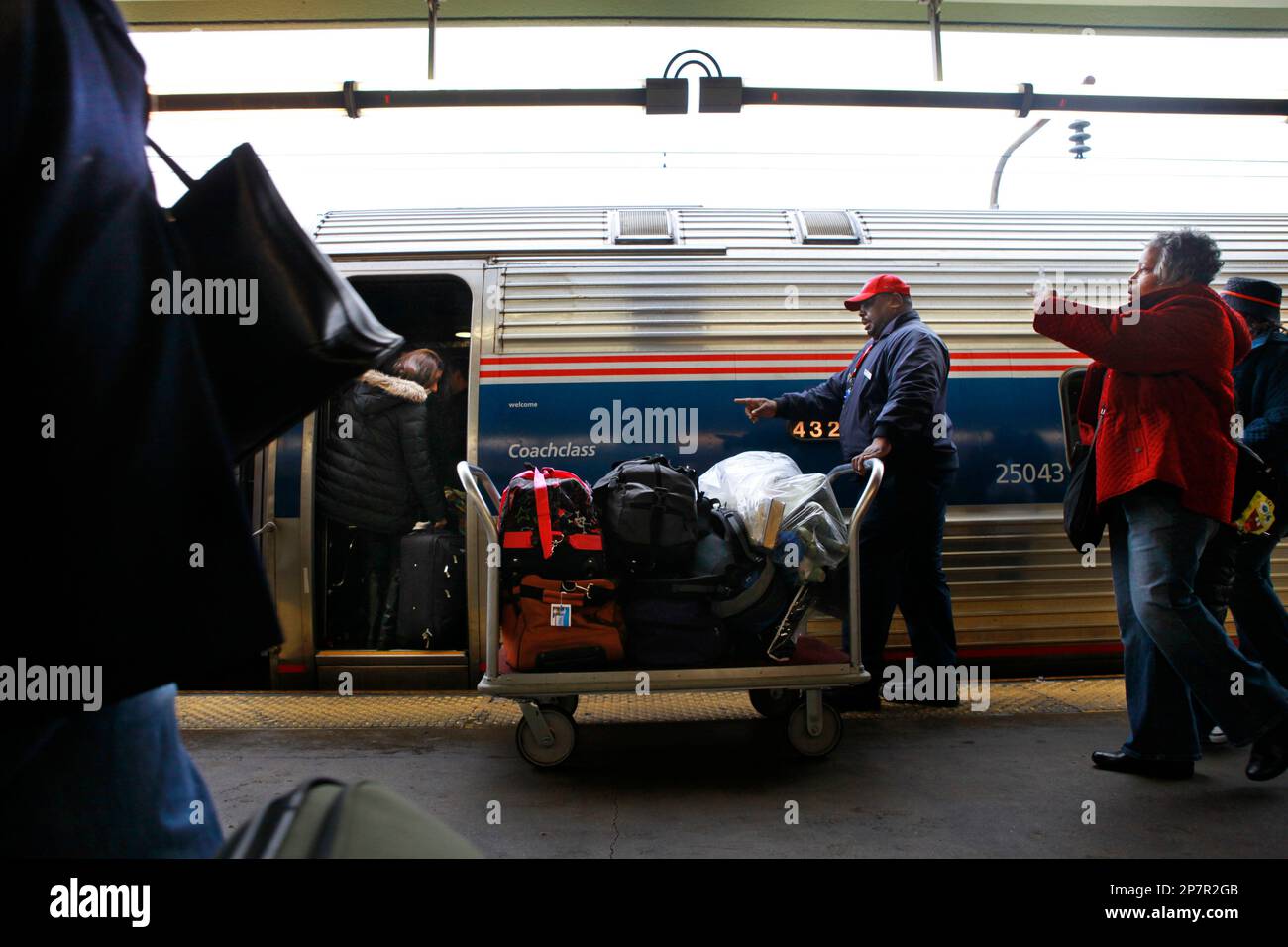 Ernest Gist, with Amtrak's Red Cap service, center, helps Jackie ...