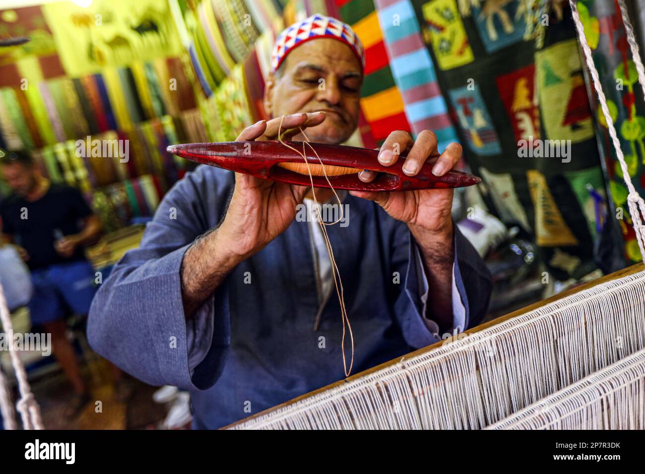 Aswan, Egypt. 8th Mar, 2023. A man prepares to weave with a loom to ...