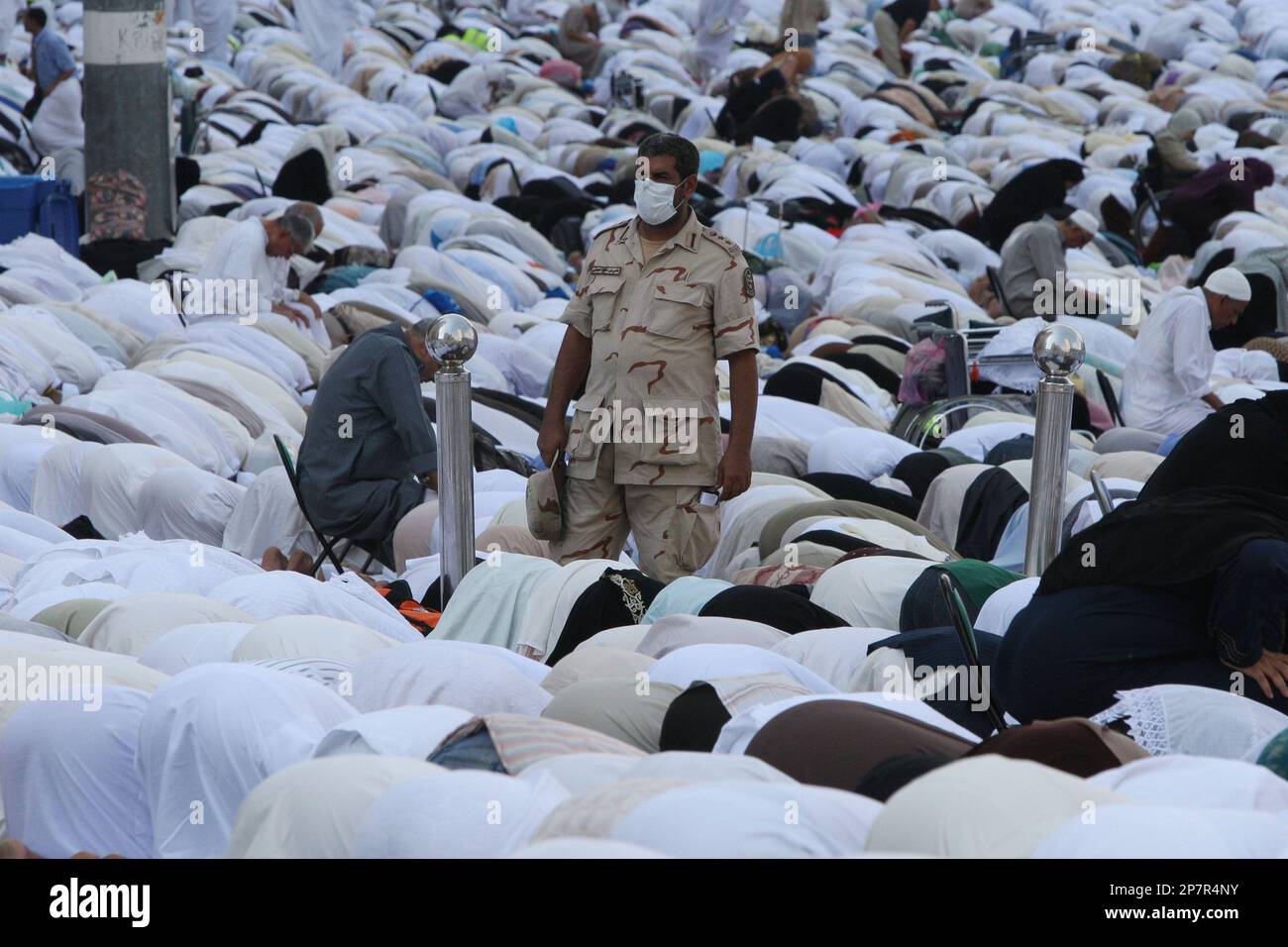 A Saudi security official wearing a protective mask keeps an eye on ...
