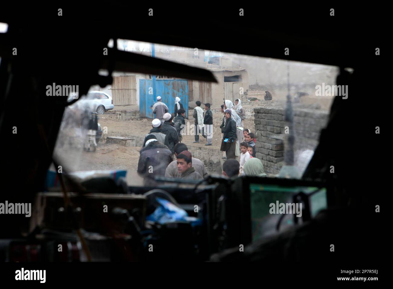 Villagers are seen from inside a U.S. Army armored vehicle belonging to ...