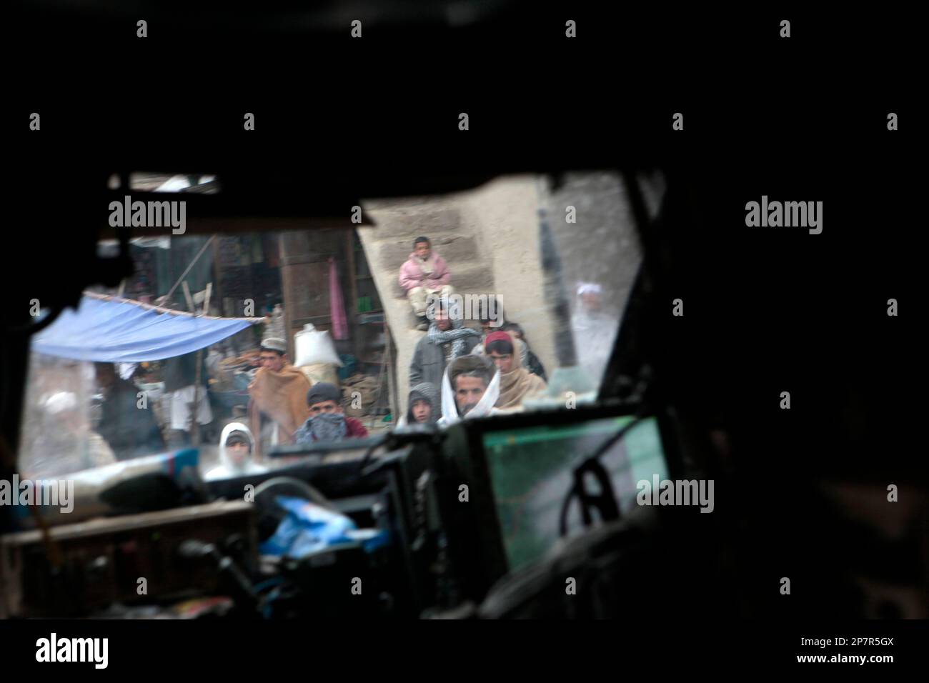 Villagers are seen from inside a U.S. Army armored vehicle belonging to ...