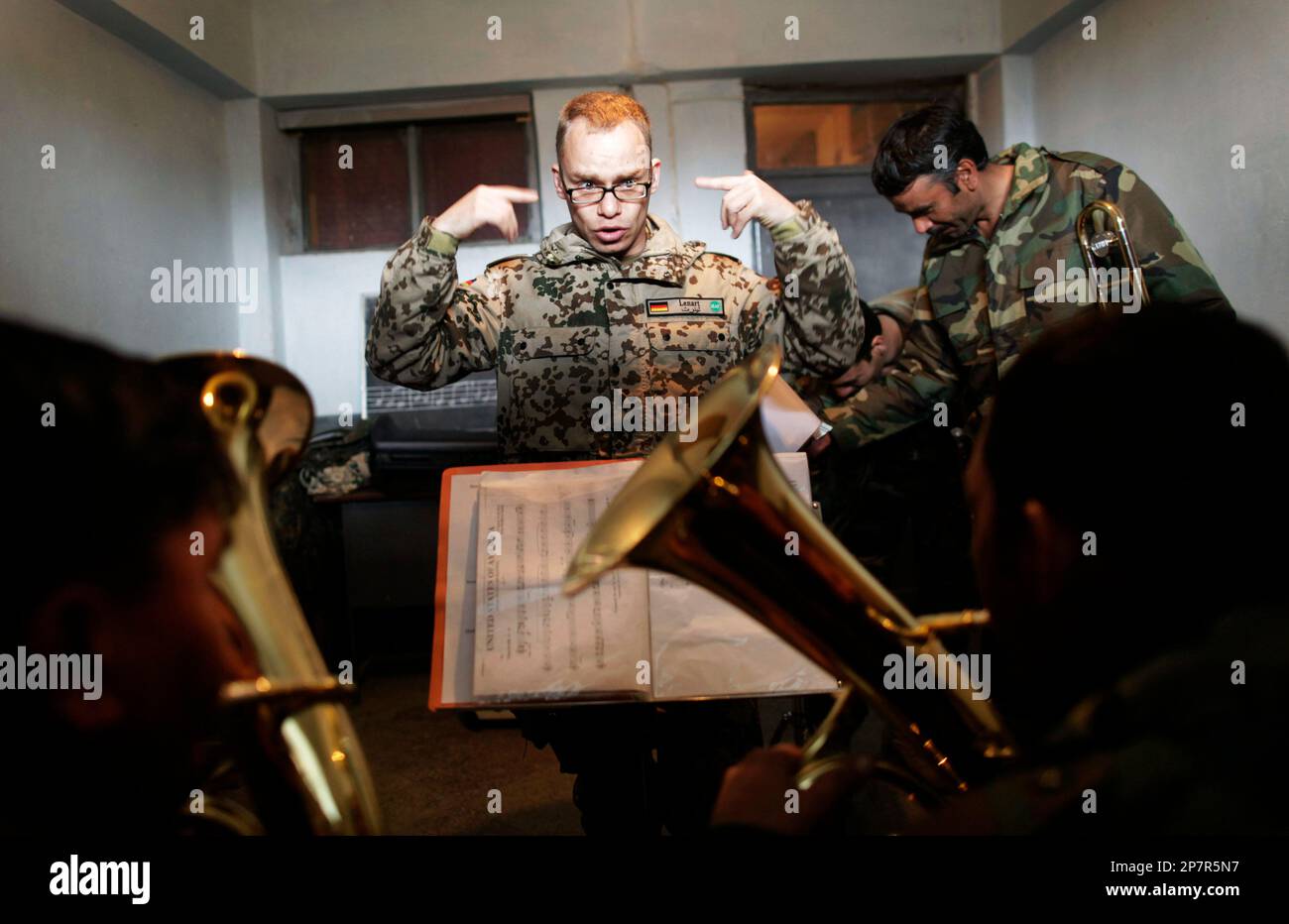 A conductor of the German army music corps, center, leads members of ...