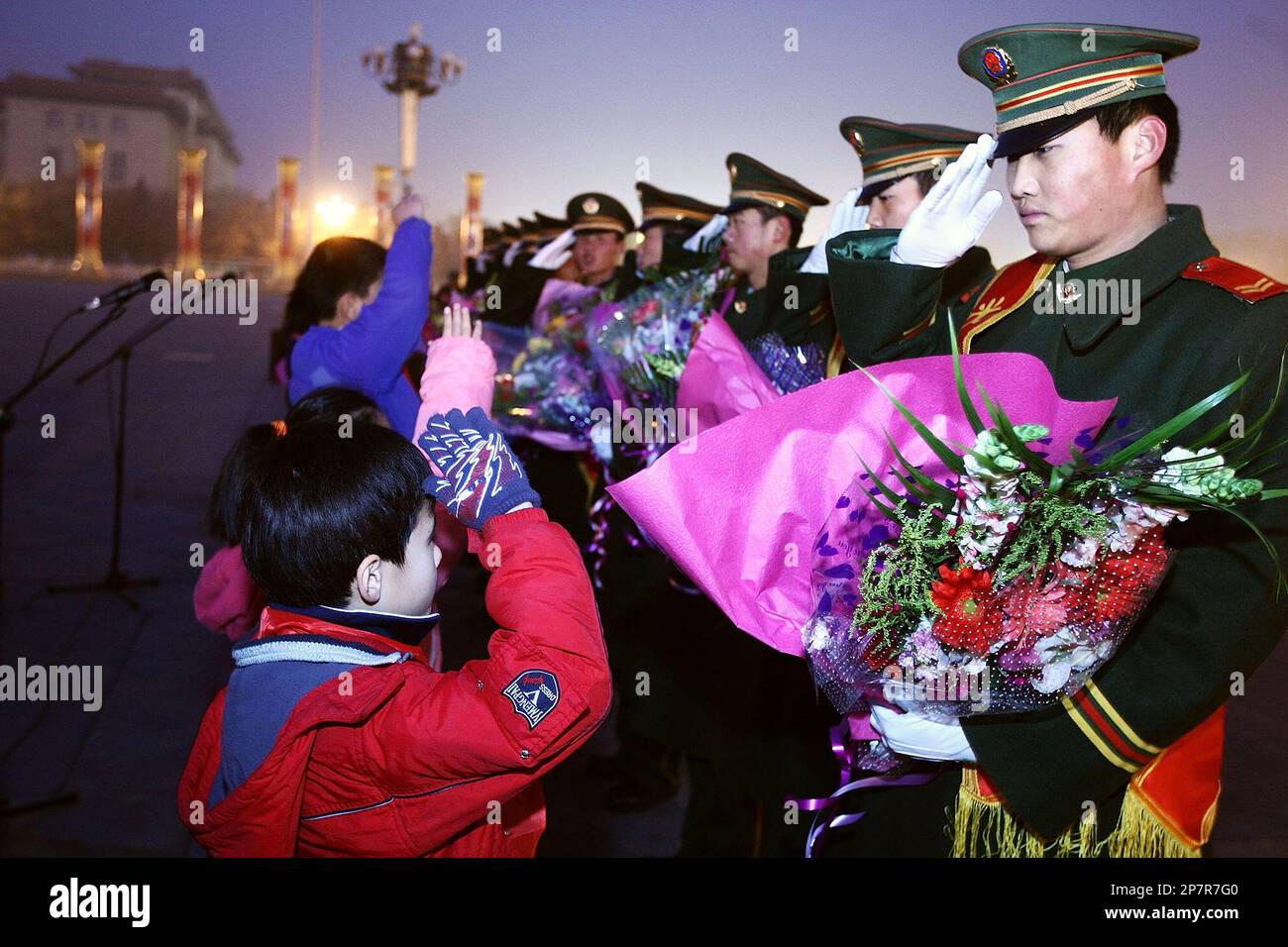 Chinese paramilitary soldiers receive flowers from pupils during a flag ...