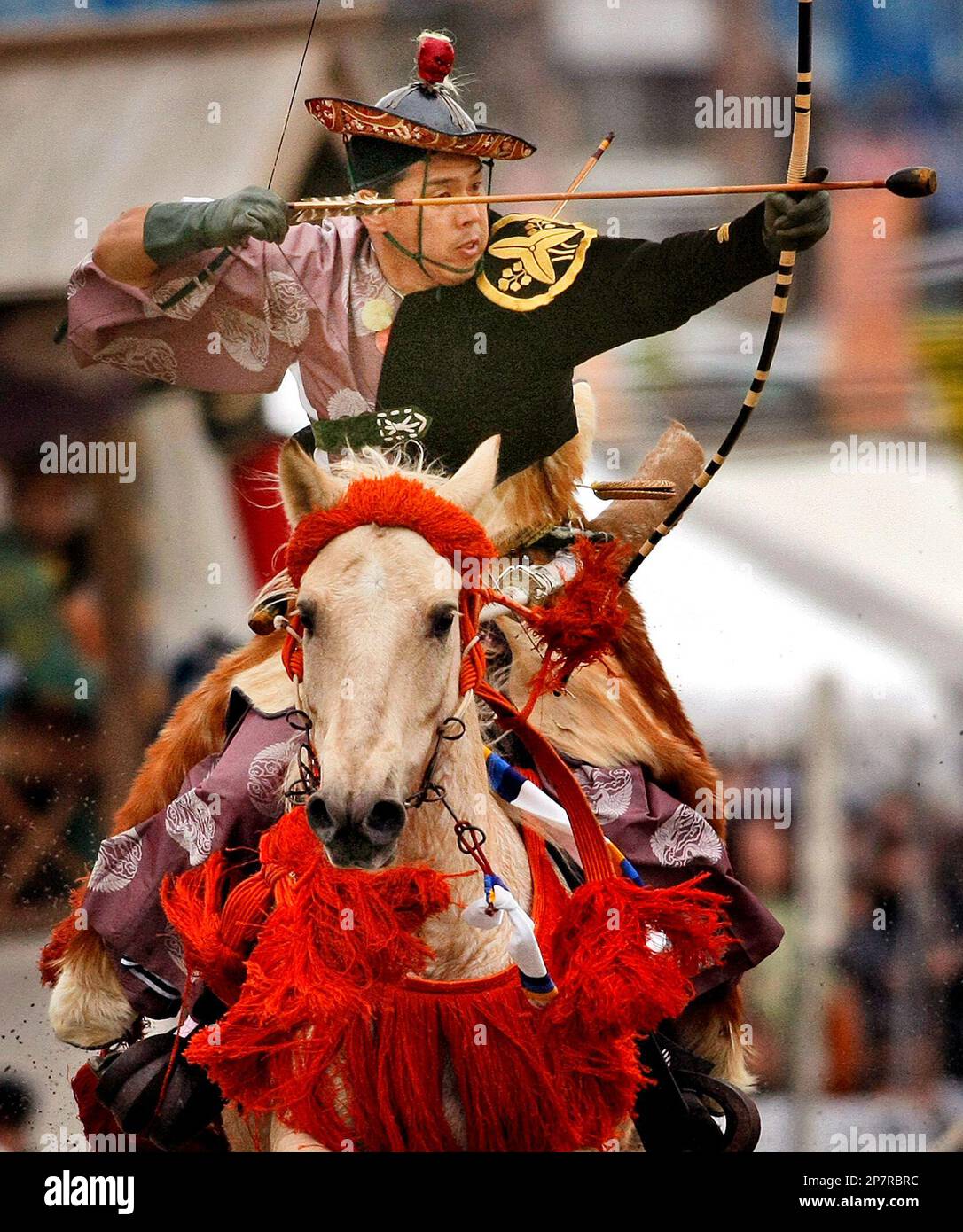 A mounted archer wearing a Samurai warrior costume aims at a target ...