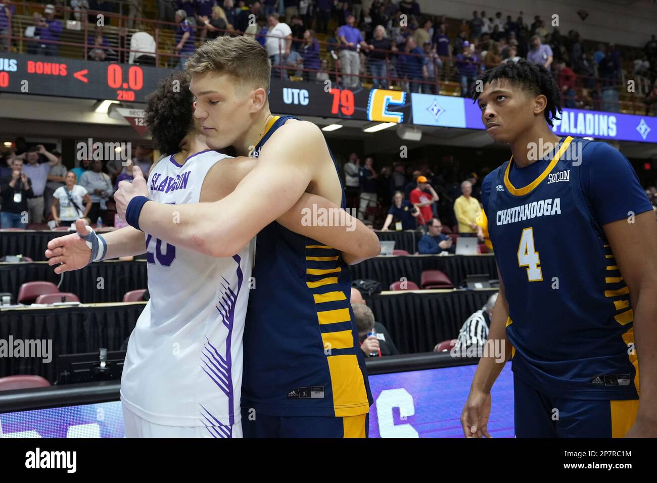 Furman forward Jalen Slawson (20) embraces Chattanooga center Jake ...