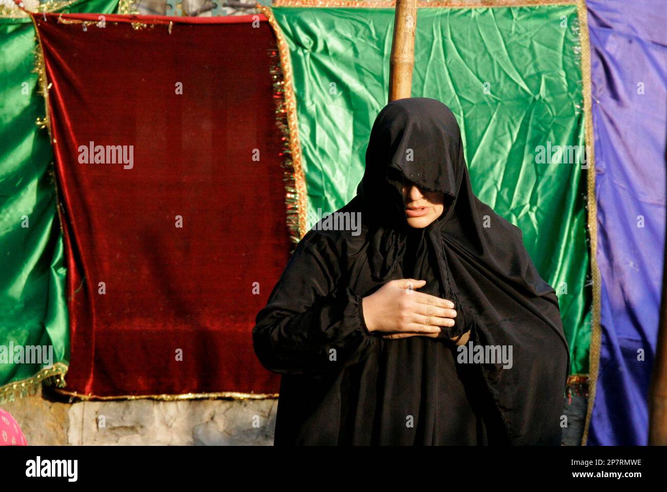 A Kashmiri Muslim woman offers prayer outside the Shah-e-Hamdan shrine ...