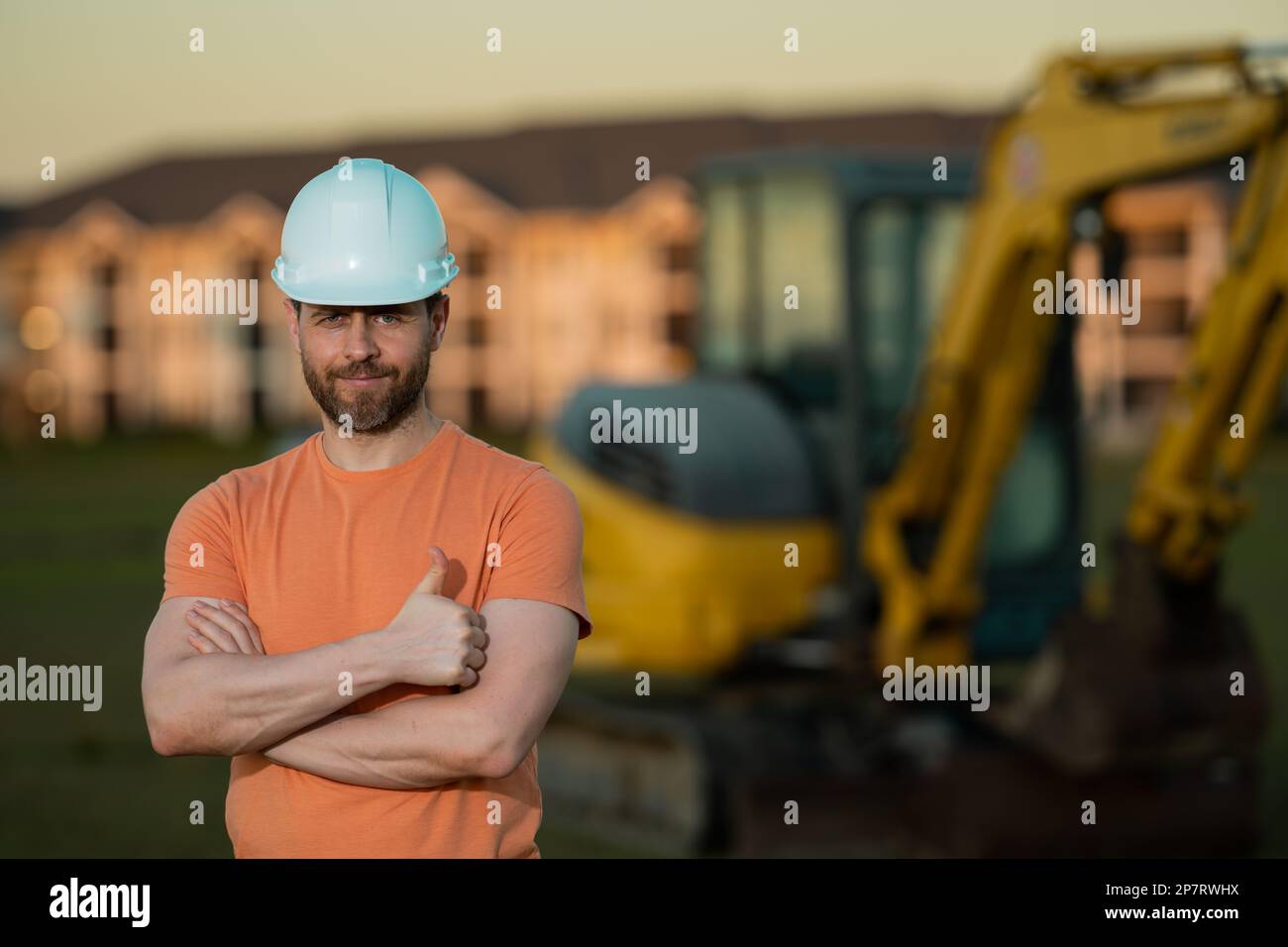 Builder in a construction site. Builder with excavator ready to build ...