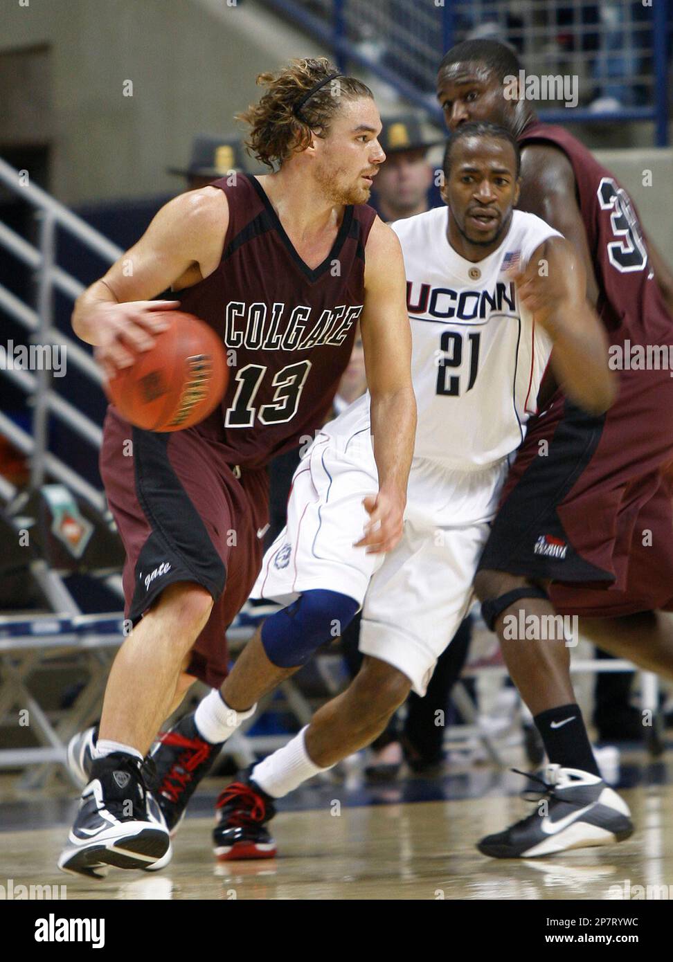 Colgate's Kyle Roemer, left, dribbles the ball past Connecticut's ...