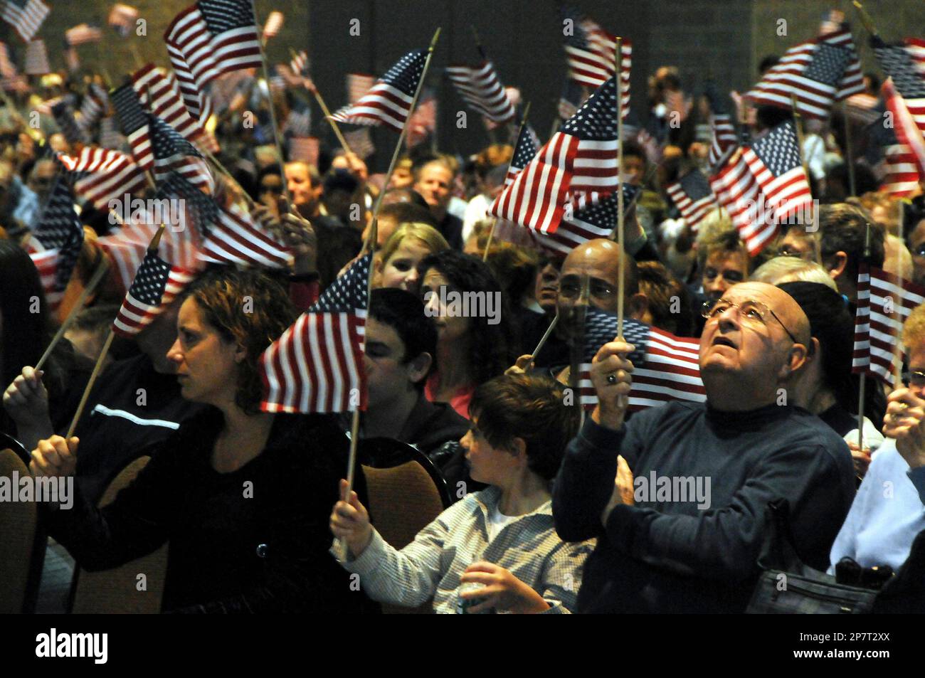 A crowd of family and friends wave flags at a send-off ceremony for the ...