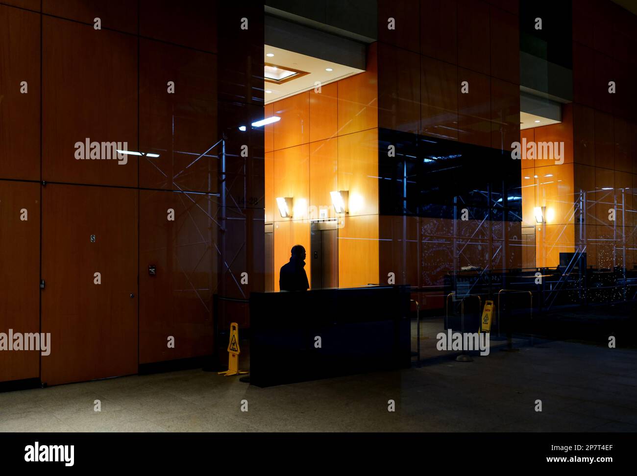 Silhouette of a security guard standing in a modern office building ...