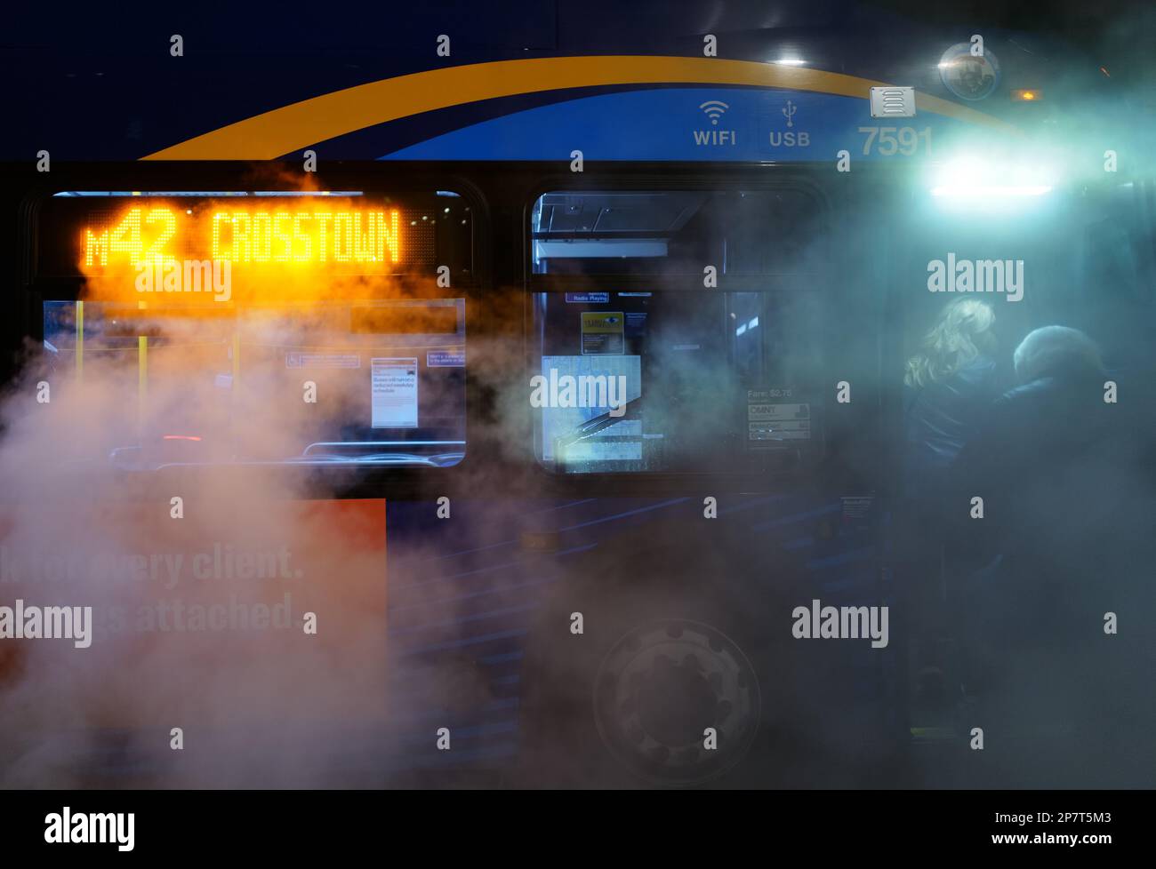 Passengers boarding a New York City bus in steam at night Stock Photo ...