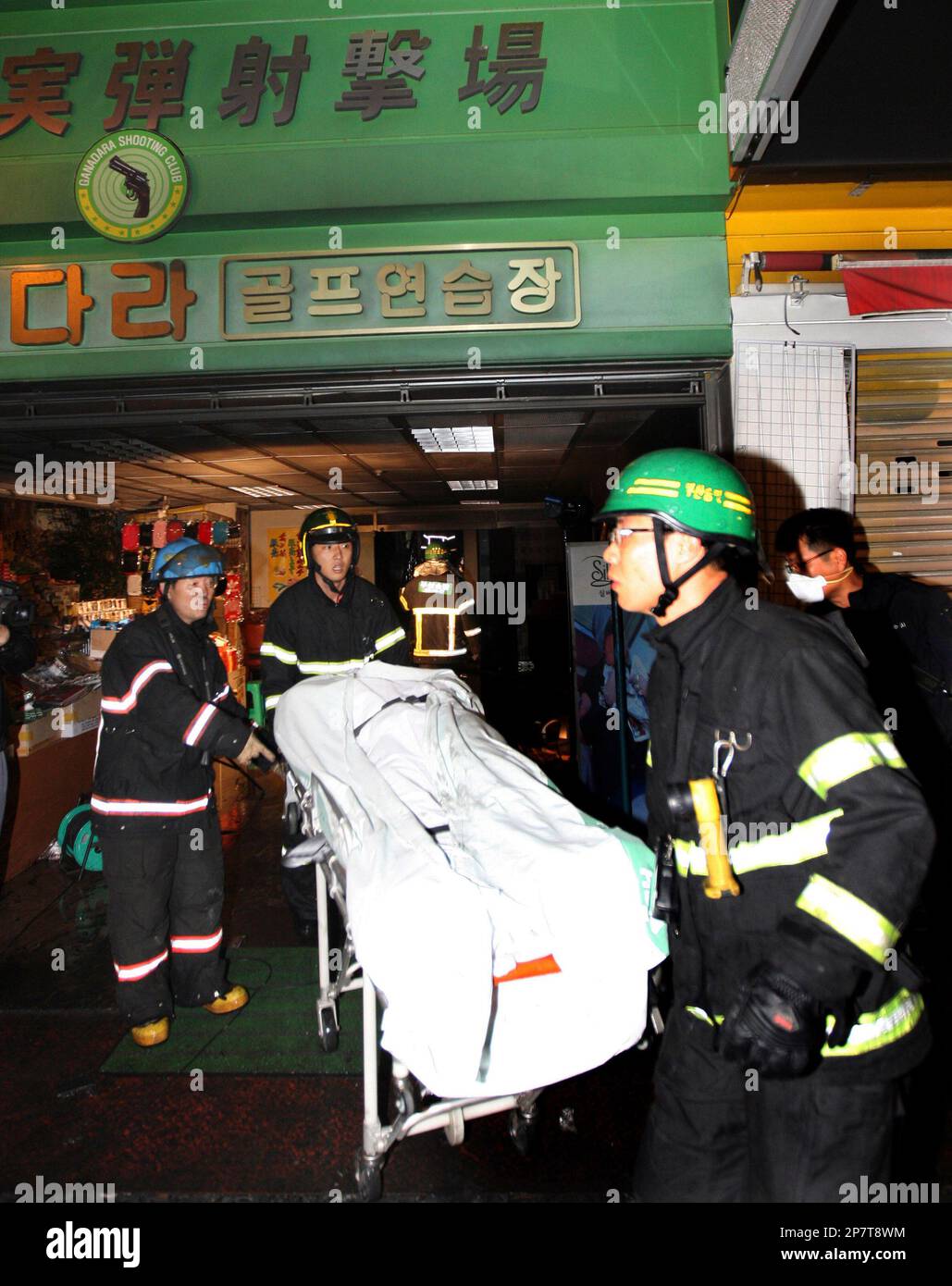 South Korean firefighters carry a body at the scene of a fire in Busan ...