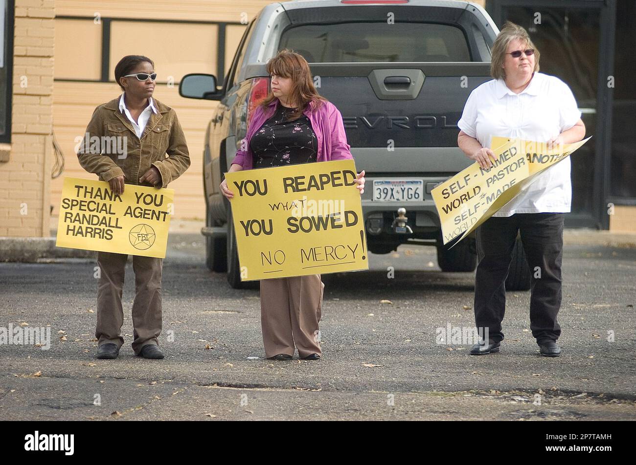 Antavia Meggs, left, Jeanne Philyaw, center, and Mary Coker hold signs ...
