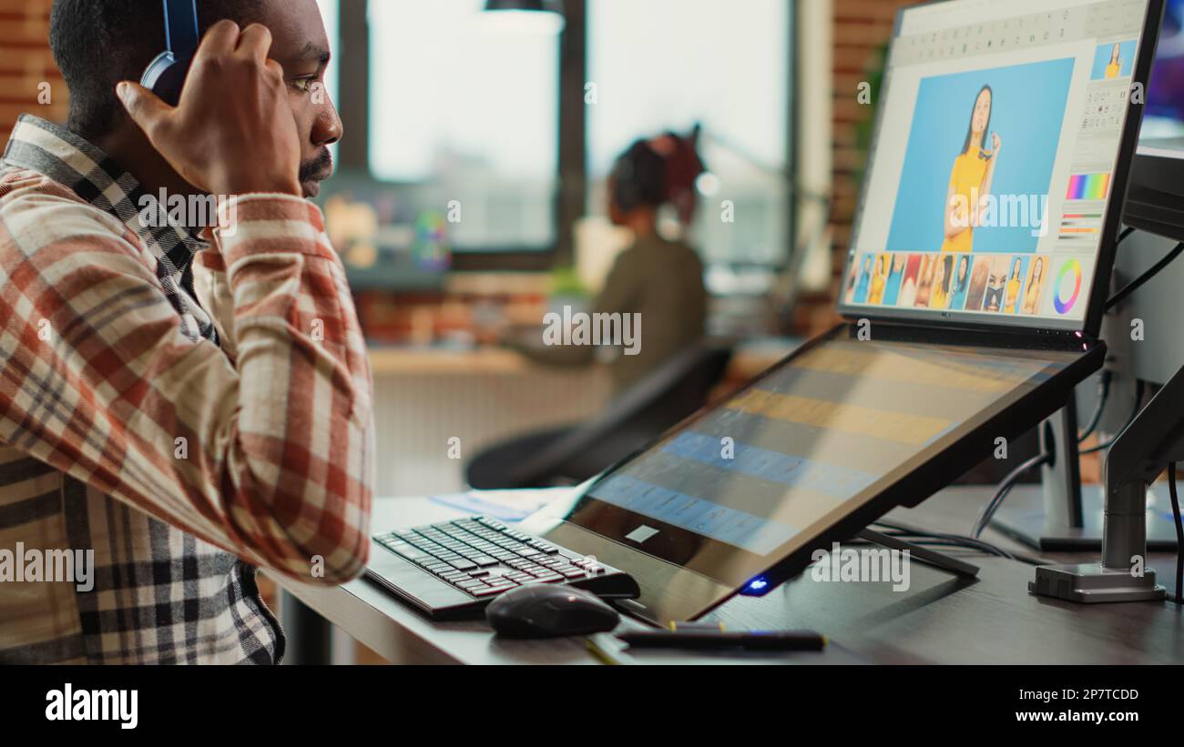 Graphic designer expert editing pictures on touchscreen monitor, using ...