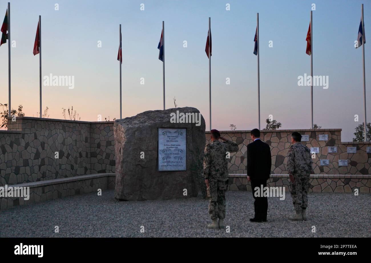 German Defense Minister Karl-Theodor zu Guttenberg, center, pays ...